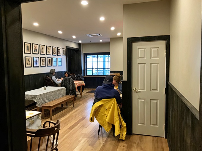 Inside, wood paneling and simple tables create that rare atmosphere where strangers become friends over shared appreciation of exceptional comfort food.