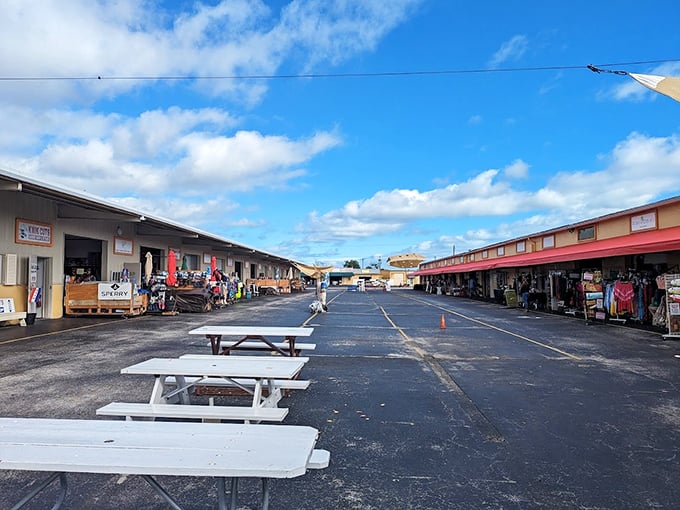 White picnic tables offer a perfect resting spot between shopping adventures, with colorful vendor buildings creating a marketplace village atmosphere.