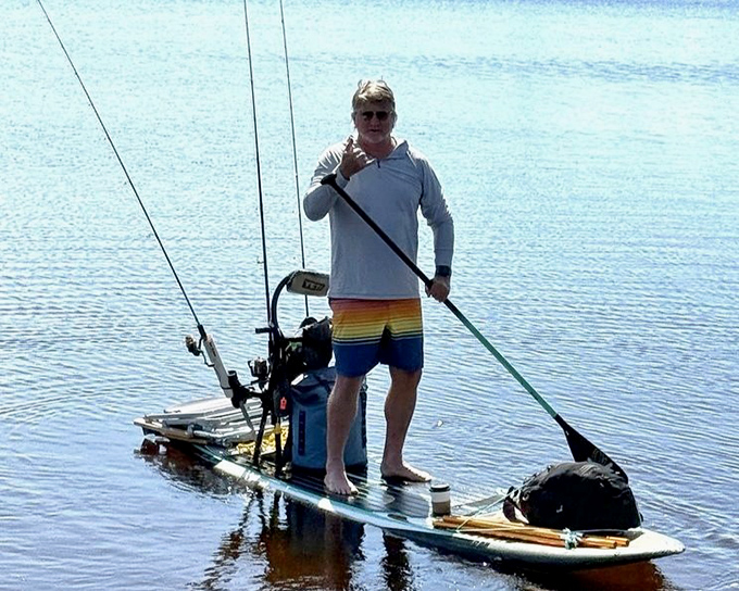 A paddleboard fisherman's serenity: Who needs a fancy boat when you can stand on water with your rod, reel, and thoughts?