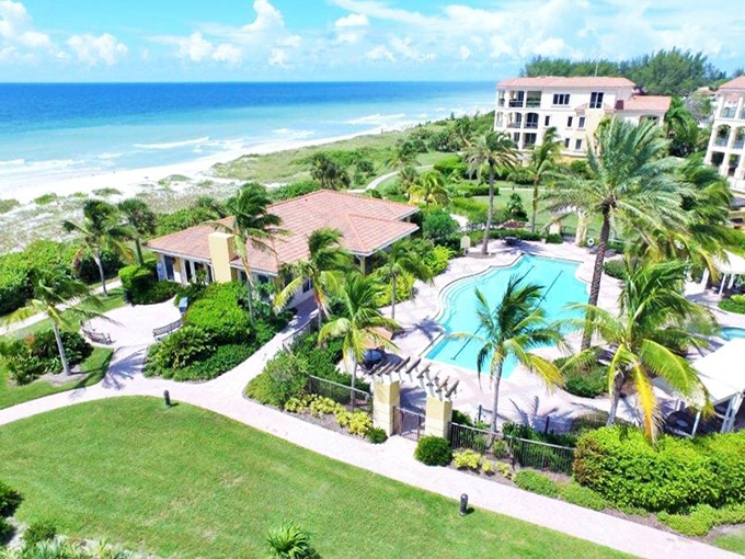 Beach living perfected: Palm trees standing guard over pristine sands and azure waters&mdash;the daily "terrible view" Longboat Key residents somehow endure.