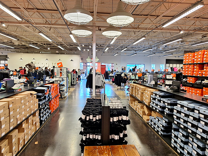 The promised land of footwear awaits. Orange boxes stacked like a shrine to the gods of athletic fashion, beckoning with their siren song of savings.