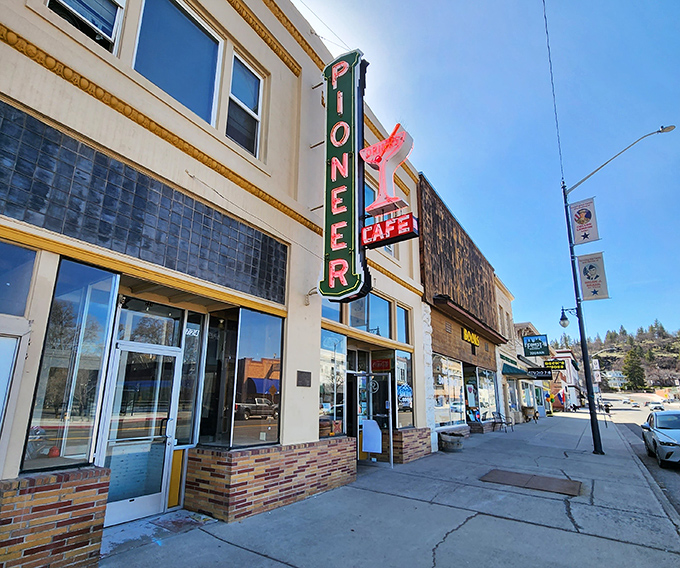 The Pioneer Cafe's vintage neon sign has been guiding hungry travelers to comfort food for generations, a beacon of pancake paradise.