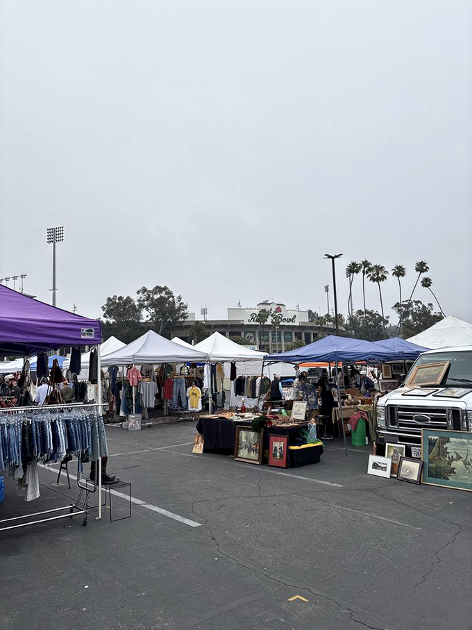 A misty morning doesn't deter dedicated shoppers. The early birds arrive with empty bags and high hopes, stadium silhouette promising adventures ahead.