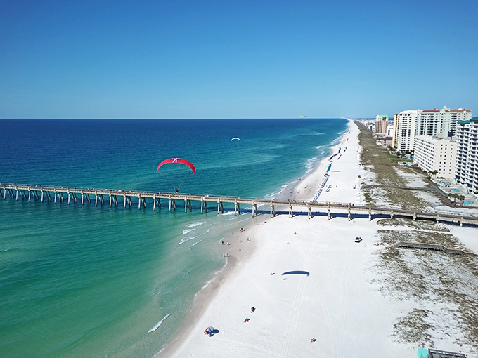 Paragliding dreams: Nothing says "I'm definitely not at my desk job" like colorful paragliders dancing above Navarre's crystal waters and that magnificent pier.