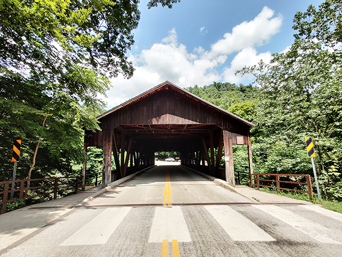 The iconic covered bridge stands like a time machine to simpler days, its weathered beams sheltering travelers just as they did generations ago.