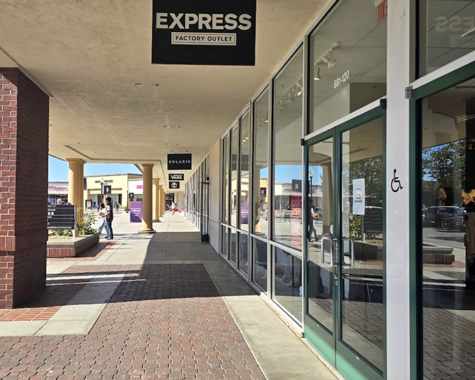 Coach's storefront beckons with promises of luxury at less painful prices. That bench isn't just for tired shoppers&mdash;it's for partners contemplating their financial futures.