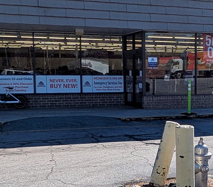 Window signs shout "Never Buy New" like a battle cry for thrifty shoppers everywhere.