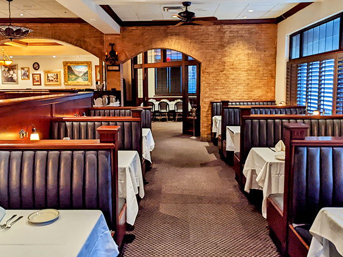 Dark wood booths and white tablecloths create that perfect steakhouse atmosphere where important conversations and serious eating happen in equal measure.
