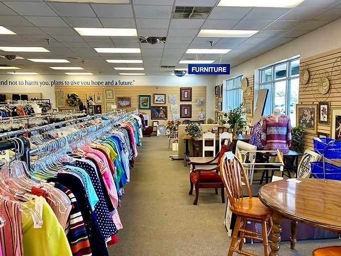Color-coded clothing racks stand at attention like soldiers guarding the gateway to vintage fashion adventures. The furniture section beckons beyond.