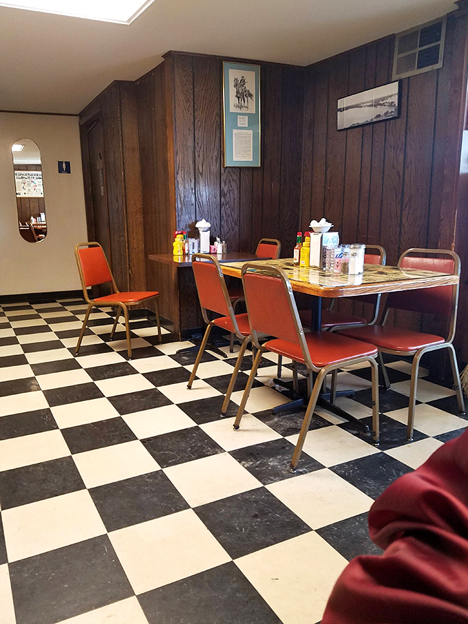 Classic diner aesthetics at their finest &ndash; wood paneling, checkered floors, and orange chairs that have cradled countless satisfied customers through decades of delicious meals.
