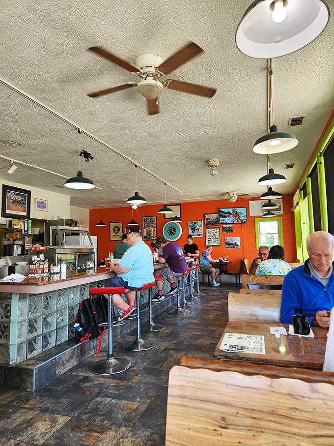 Classic counter seating, orange walls, and ceiling fans spinning stories&mdash;this isn't retro by design, it's authentic by survival.