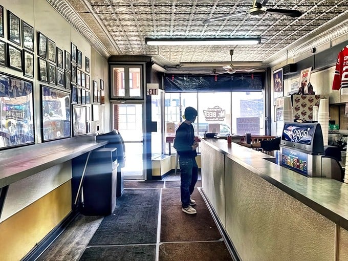 Step inside and time stands still. The narrow ordering counter, classic tin ceiling, and wall of memories tell you this place means business.