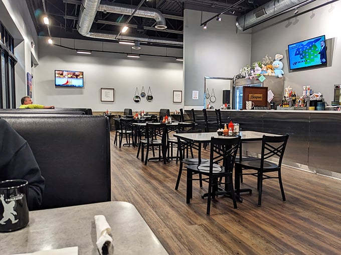 Modern meets cozy inside with warm wood floors, comfortable black booths, and an open ceiling. The kind of place where breakfast dreams and lively conversations flourish equally.