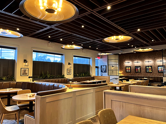 Golden pendant lights cast a warm glow over the dining room, where modern design meets cozy comfort in perfect Italian harmony.