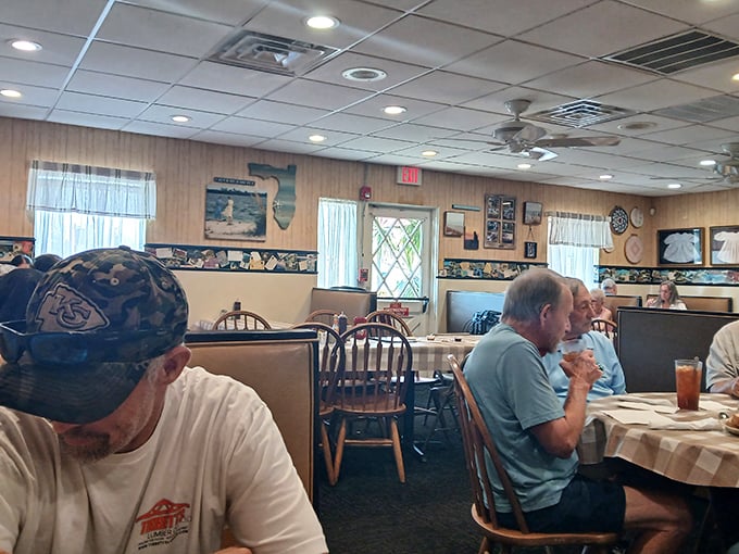 Step inside where wooden tables and checkered charm create the perfect backdrop for serious comfort food conversations.