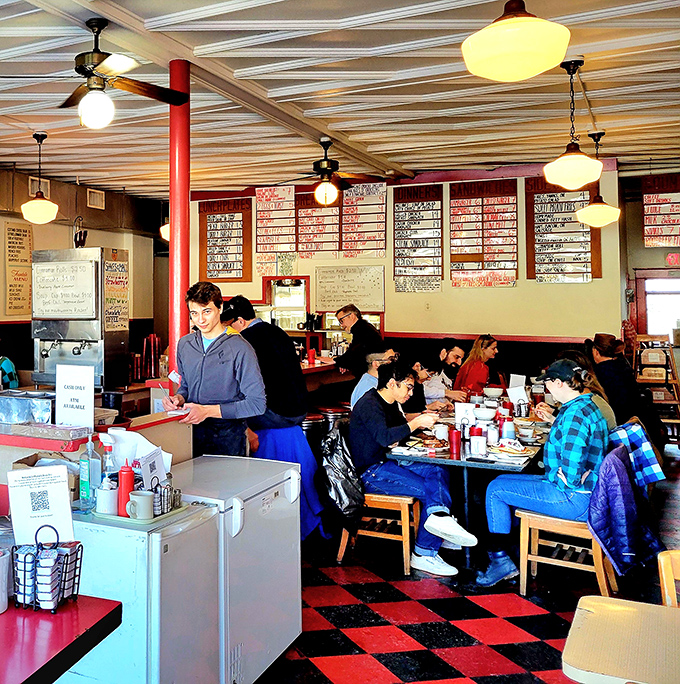 The interior is a symphony of organized chaos&mdash;red and black checkerboard floors, handwritten menu boards, and the constant buzz of satisfaction.