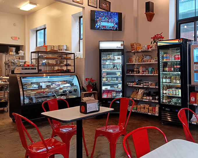 Red metal chairs pop against industrial simplicity &ndash; this isn't just a sandwich shop, it's a neighborhood gathering spot where food dreams come true.