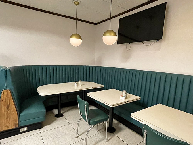Sliding into these teal vinyl booths feels like time travel with better upholstery. The globe lights cast the perfect "everyone looks good here" glow.