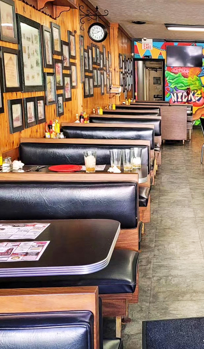 Classic black vinyl booths line wood-paneled walls covered in local history. This isn't manufactured nostalgia—it's the real deal earned through decades of service.