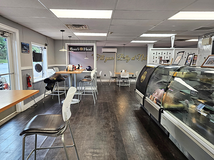 Simple tables, Boar's Head sign, and that golden "Fill your Belly at Nick's" wall art. This isn't dining theater&mdash;it's the honest stage where sandwich magic happens.