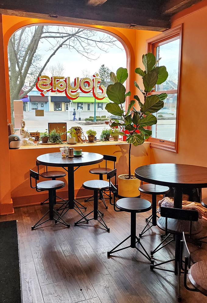 Sunshine-orange walls and fiddle leaf figs create the world's coziest dining nook. It's like eating in Wes Anderson's breakfast club.