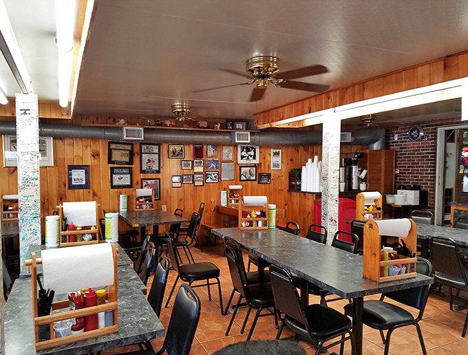 Wood-paneled walls tell stories of BBQ pilgrimages past, while paper towel rolls stand ready for the delicious mess that awaits.
