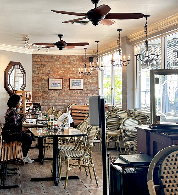 Exposed brick walls, bistro chairs, and ceiling fans create that perfect "I've found my new favorite spot" atmosphere.