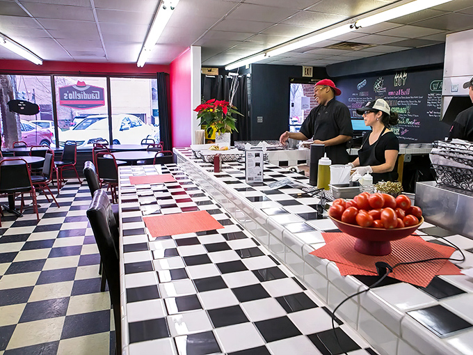The black and white checkered floor sets the stage for sandwich artistry, while fresh tomatoes wait patiently for their starring role.