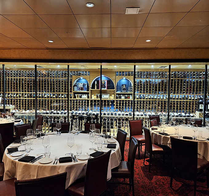 Wine bottles stand like silent sentinels behind glass, guarding the dining room where life-changing meals happen daily. The sommelier's playground meets carnivore paradise.