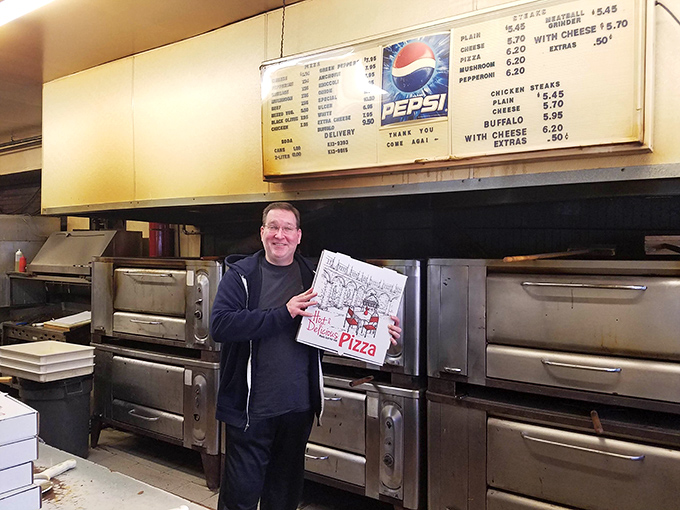 Behind the counter where pizza magic happens. Those well-worn ovens have probably produced enough pies to circle Pennsylvania a few times over.