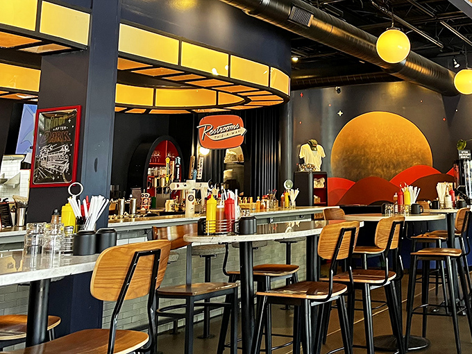 Inside, a cosmic collision of mid-century design and modern flair. That orange planetary backdrop isn't just d&eacute;cor&mdash;it's a promise of orbit-shifting flavors.