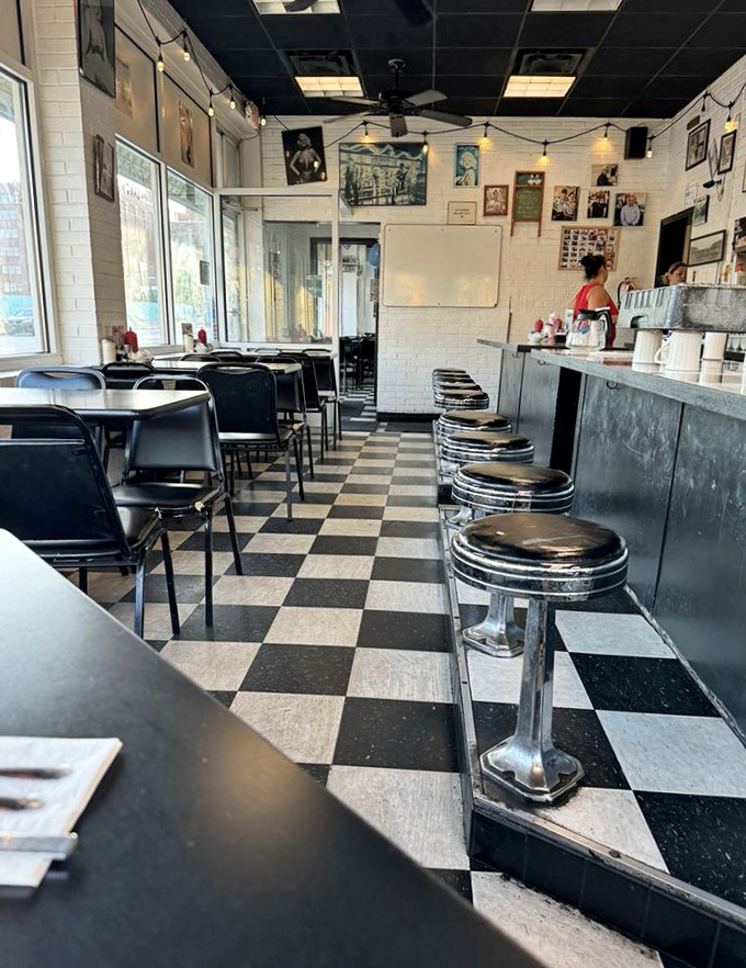 Classic chrome stools line the counter where breakfast dreams come true, while the iconic checkerboard floor says "yes, you've arrived at diner heaven."