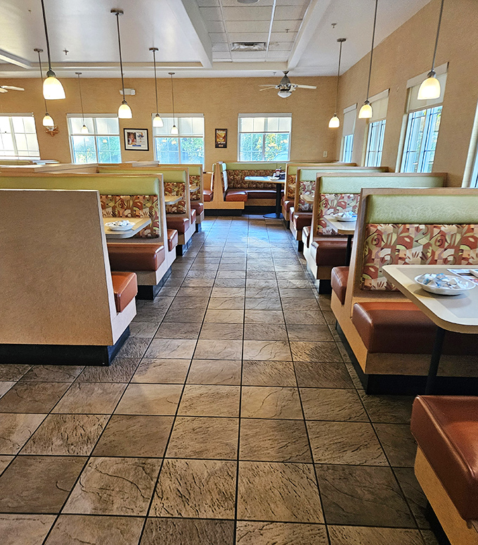 Cozy booths with floral upholstery and warm pendant lighting create that perfect diner atmosphere—where conversations flow as freely as the coffee.