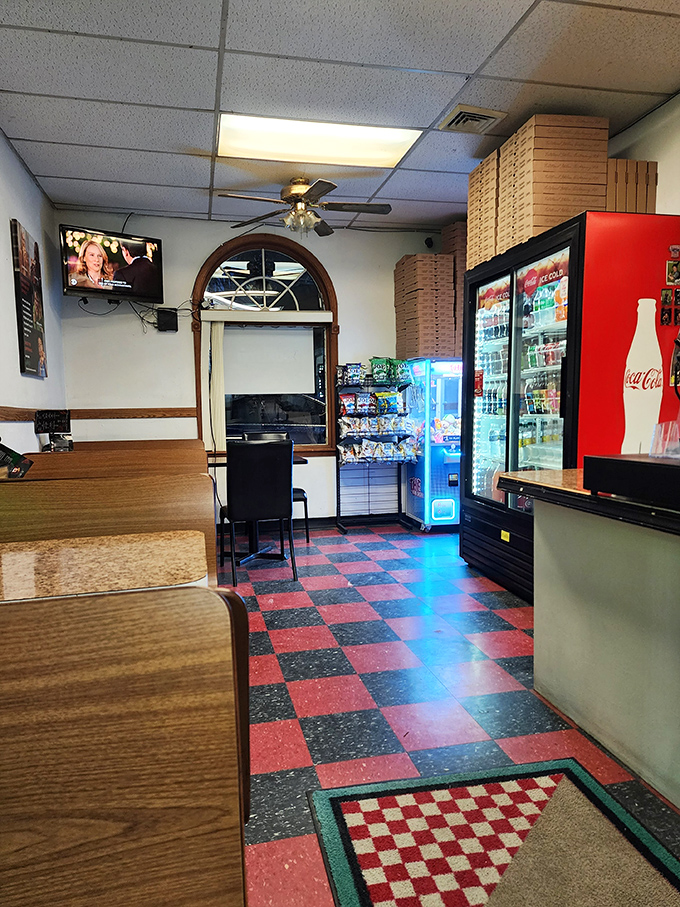 Where pizza dreams come true. The checkerboard floor and stacked pizza boxes tell you this isn't their first rodeo in the art of feeding hungry travelers.