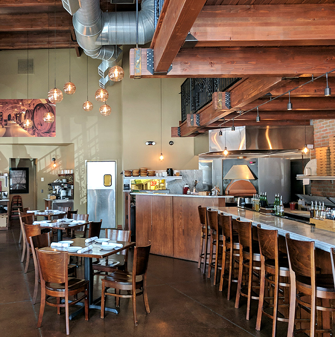 Exposed wooden beams meet industrial chic in this warm interior where every table feels like the best seat in the house.