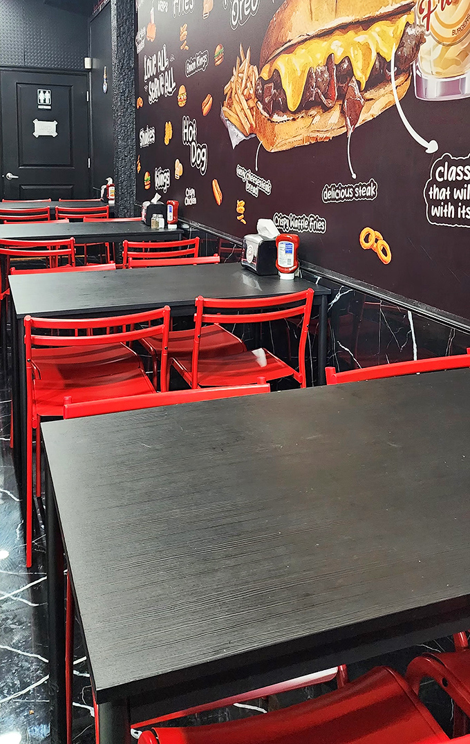 Red chairs against black tables create that perfect diner vibe where calories don't count and conversations flow as freely as the melted cheese on your sandwich.