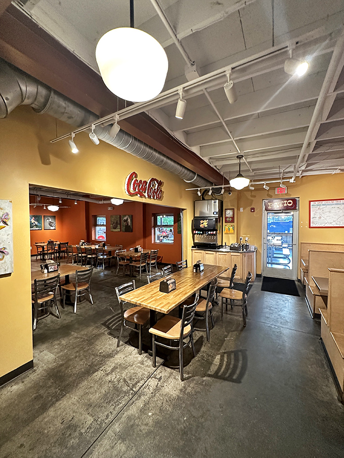 Sunshine-yellow walls, wooden tables, and that iconic Coca-Cola sign create the perfect backdrop for chicken-induced euphoria.