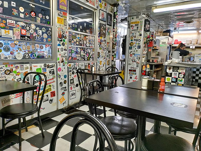 Sticker-covered walls tell the stories of thousands who came before you, creating a living museum of diner culture where every surface has something to say.