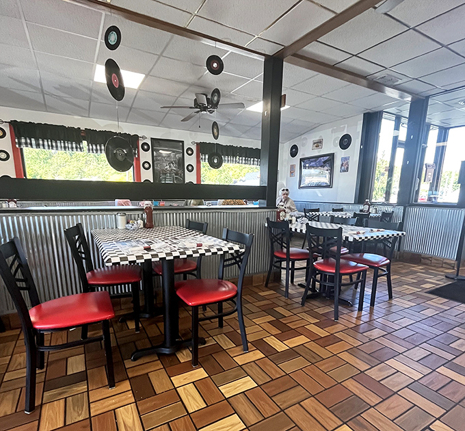 Vinyl records suspended from the ceiling like musical planets orbiting those red vinyl seats&mdash;a retro galaxy where comfort food is the star.