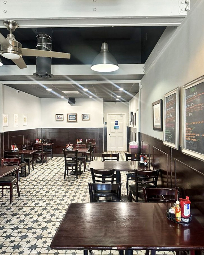 Classic black and white tiles meet warm wood wainscoting in this cozy interior that feels like breakfast at your coolest friend's house&mdash;if your friend were an exceptional cook.