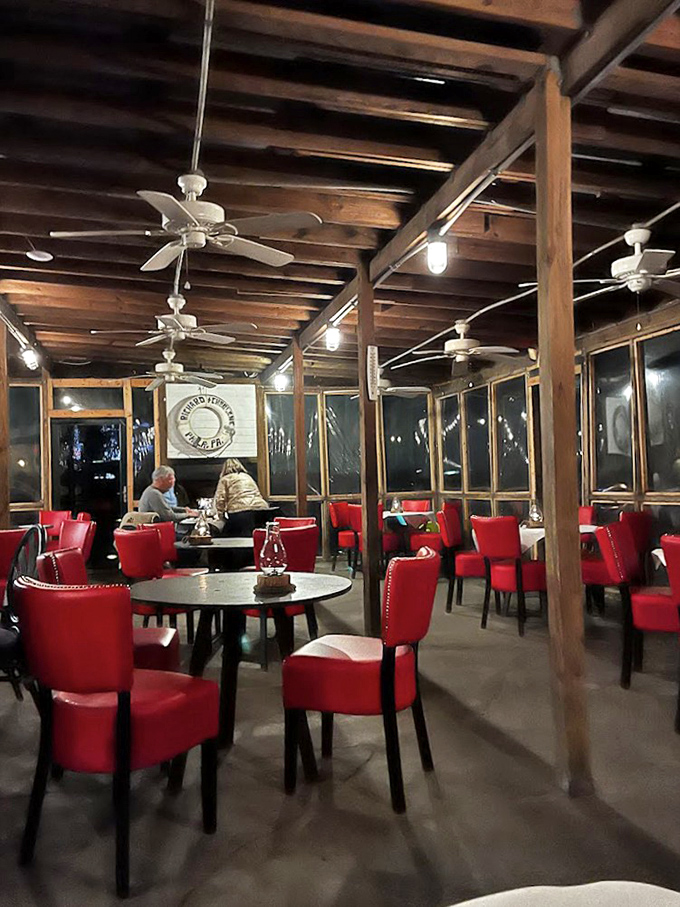 Those vibrant red chairs aren't just a pop of color &ndash; they're the perfect perch for seafood enthusiasts who know that sometimes the best dining rooms look like ship cabins.