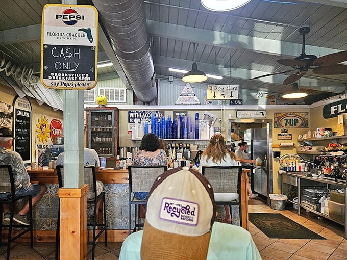 The "CASH ONLY" sign hanging from vintage Pepsi memorabilia tells you everything about this place's delightful old-school priorities.