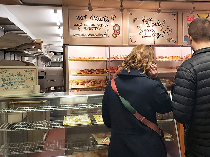 Decision paralysis strikes hard at the display case. The internal negotiation begins: "I'll just get one... okay, maybe three... fine, a dozen it is!"