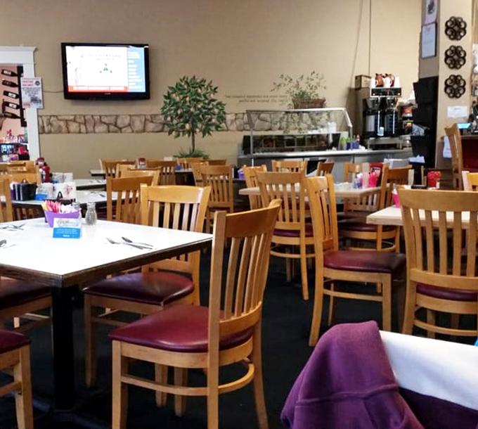 Classic diner seating where strangers become friends over coffee. Those wooden chairs have supported thousands of happy, full bellies.