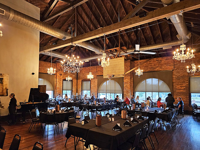 Crystal chandeliers dance above exposed brick walls and wooden beams, creating that rare alchemy where industrial chic meets Southern hospitality.
