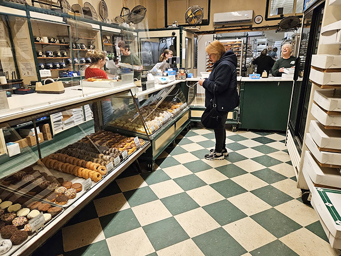 Step into a time capsule where checkerboard floors and glass cases have witnessed decades of morning rituals and sugar-fueled smiles.