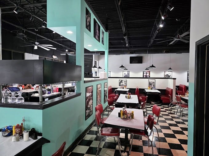 Classic black and white checkered floors meet mint green walls and cherry-red booths&mdash;this isn't just decoration, it's a full-blown time machine for your taste buds.