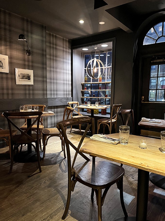 Plaid wallpaper meets rustic wooden tables in this cozy dining nook. It's like your sophisticated friend's country house, if that friend had impeccable taste in bourbon.
