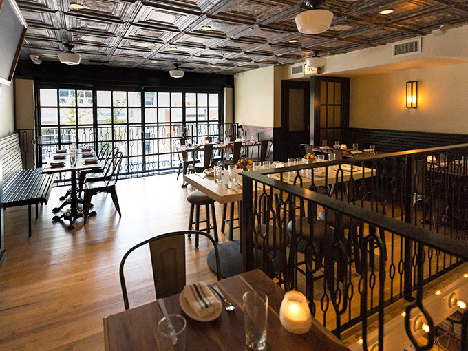 The ornate tin ceiling and warm wooden floors create that perfect sweet spot between "fancy enough for a celebration" and "comfortable enough to linger."