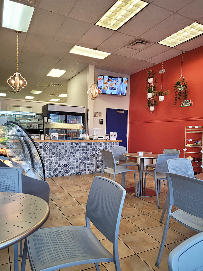Coral accent walls, hanging plants, and those distinctive blue-patterned tiles create the perfect backdrop for breakfast dreams to unfold.